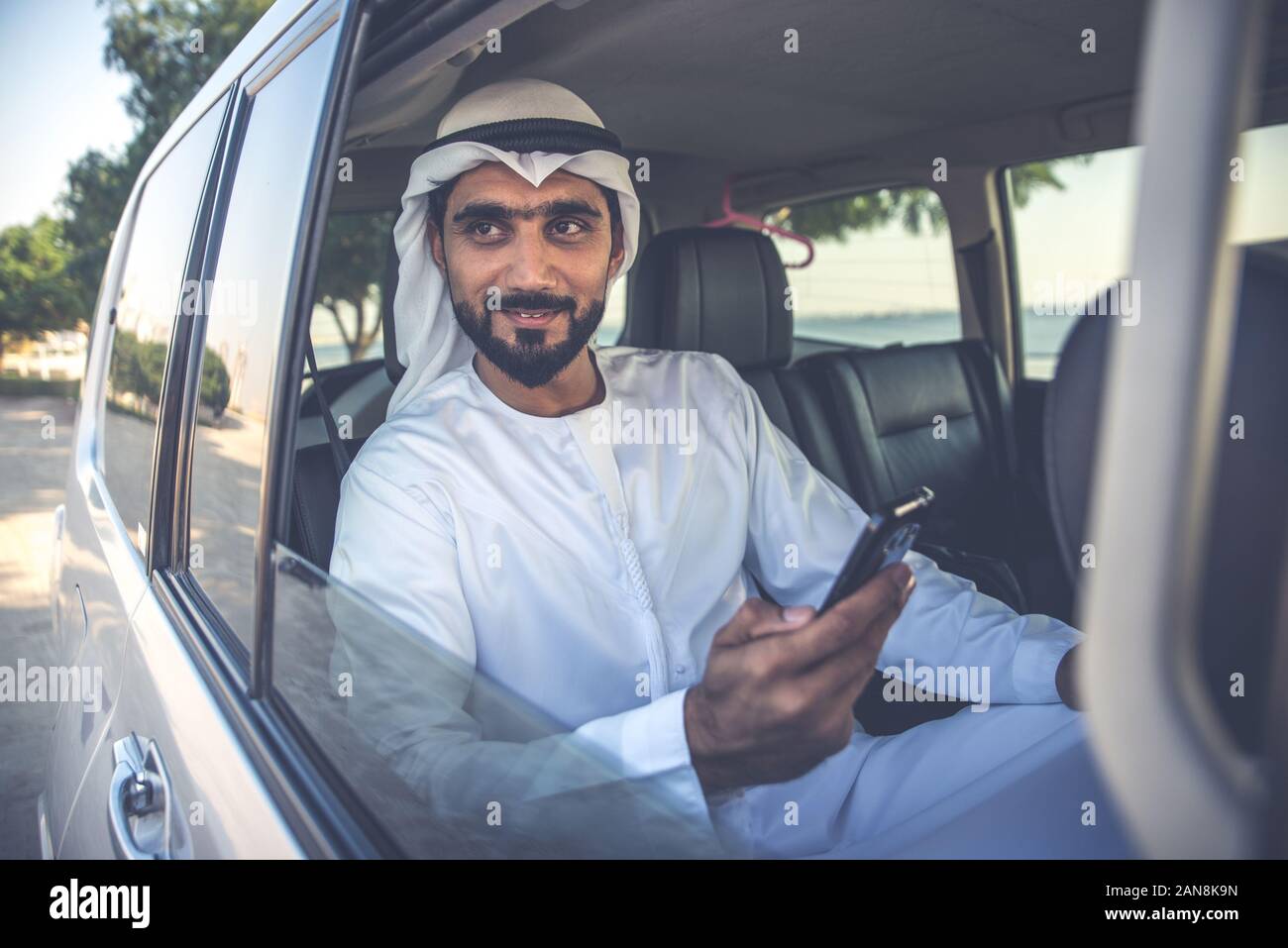 Handsome man with uae traditional outfit sitting in a car in Dubai ...