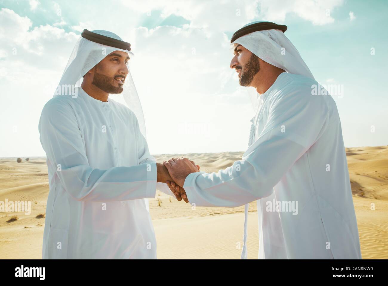 Two business men wearing traditional uae white kandura spending time in ...