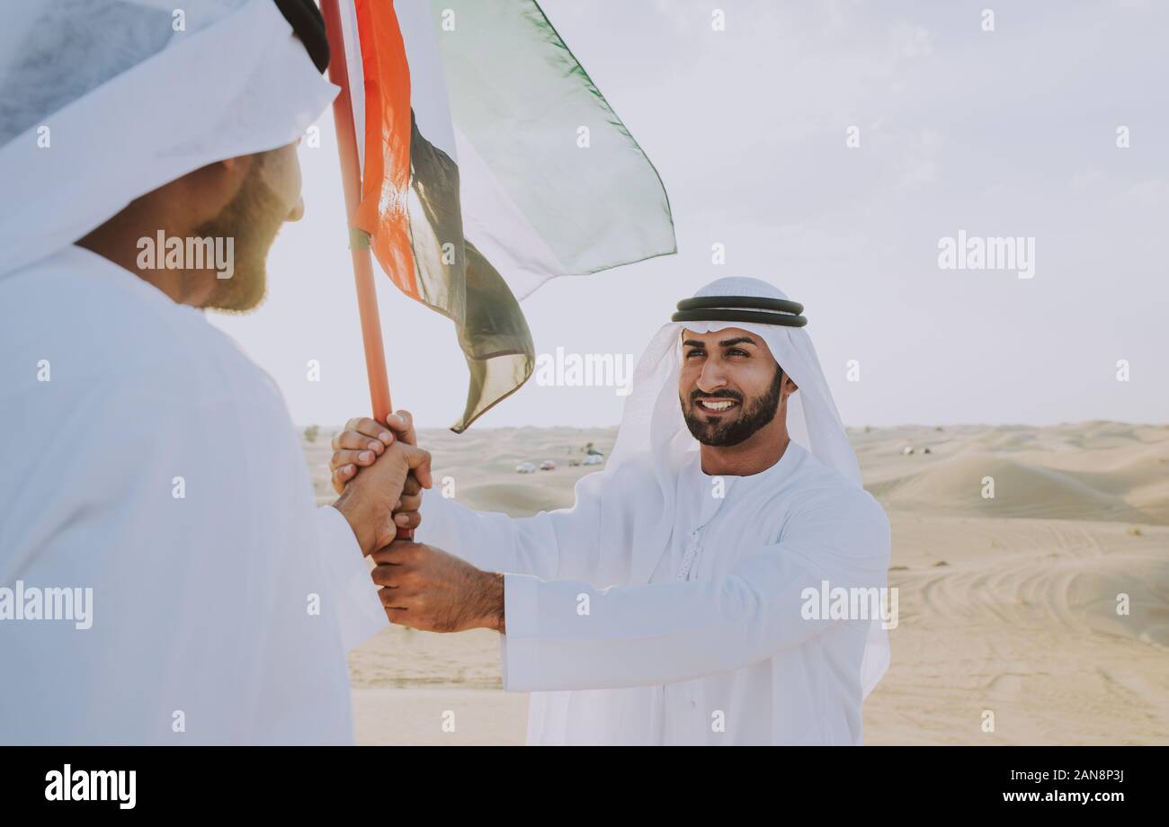 Two business men wearing traditional uae white kandura spending time in ...