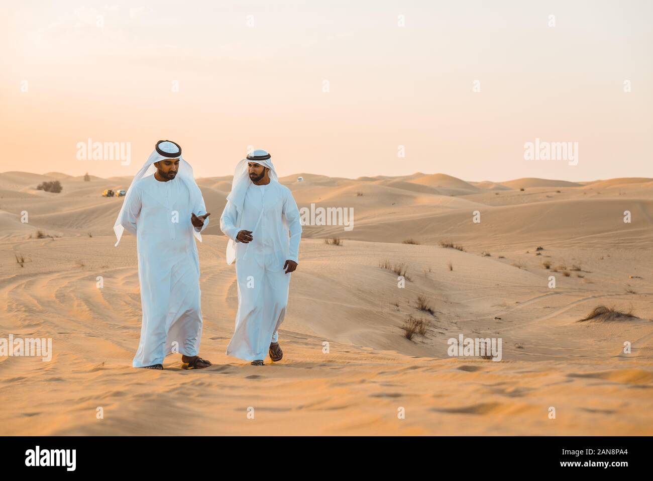 Two business men wearing traditional uae white kandura spending time in ...