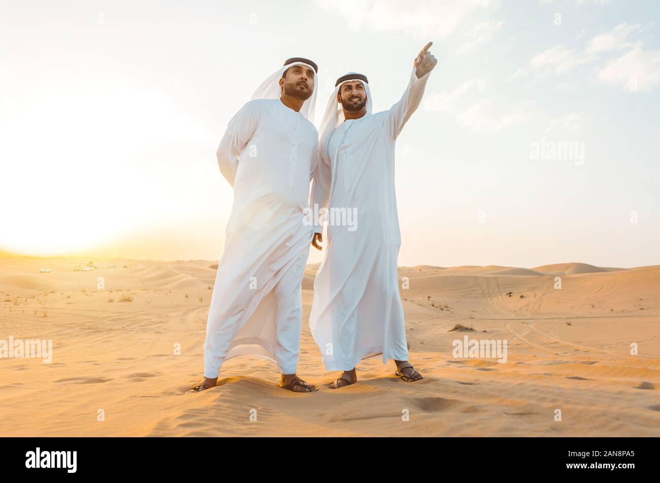 Two business men wearing traditional uae white kandura spending time in ...