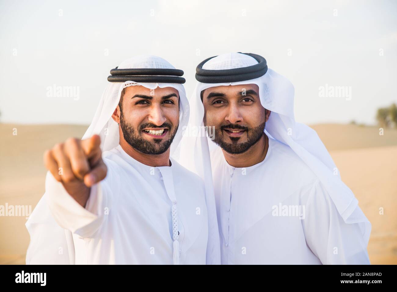 Two business men wearing traditional uae white kandura spending time in ...