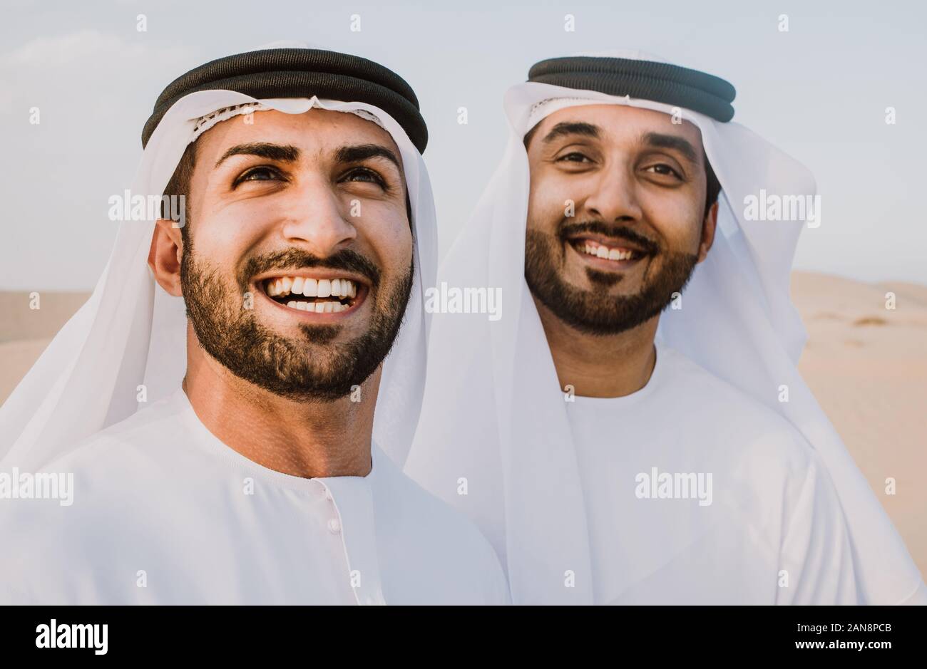 Two business men wearing traditional uae white kandura spending time in ...