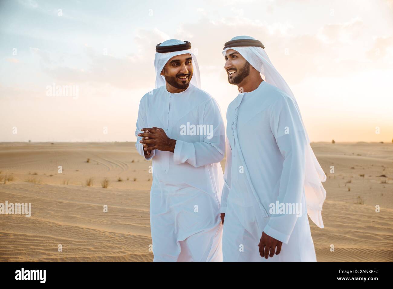 Two business men wearing traditional uae white kandura spending time in ...