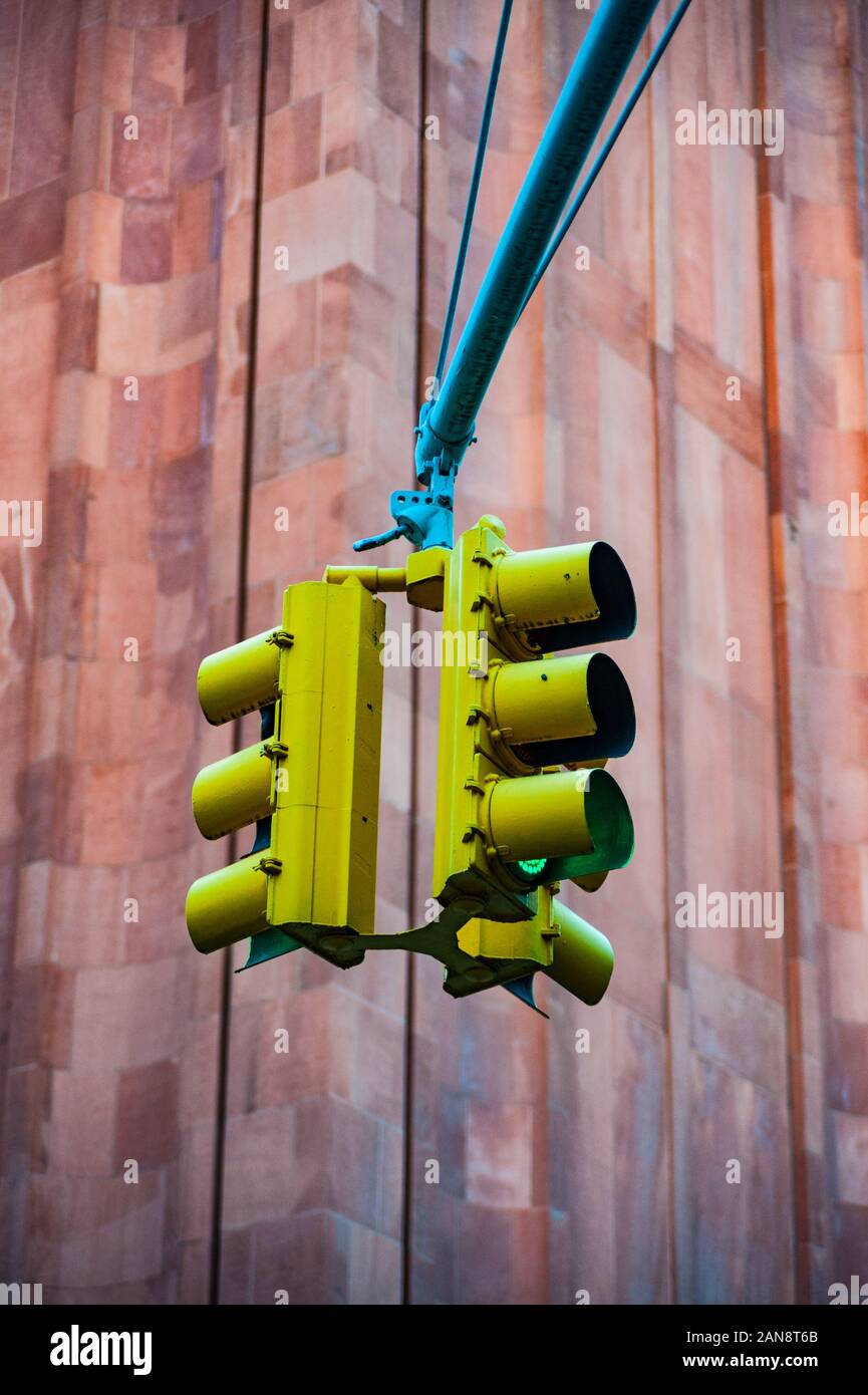 Hanging yellow street traffic lights on green , abstract stone building ...