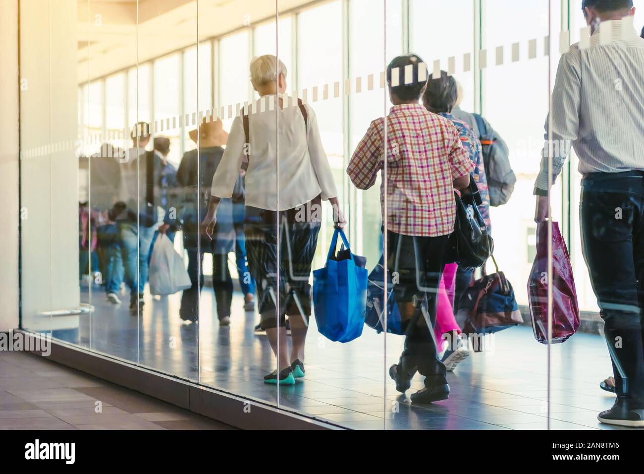 Back view of passengers and traveling luggage walking the airplane ...