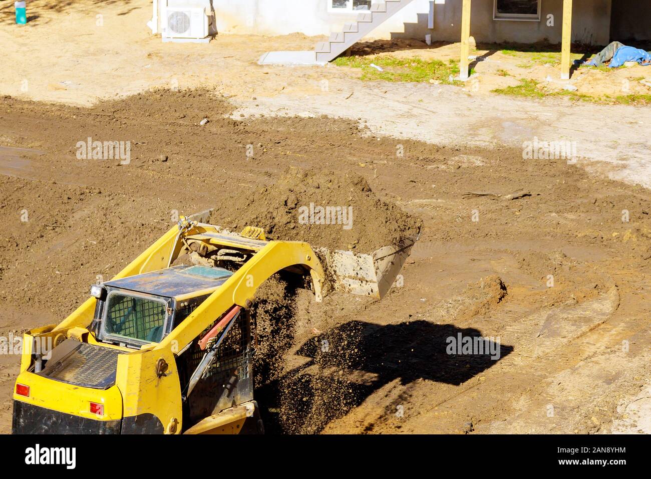 Bulldozer moving, leveling ground at construction site in ground using ...