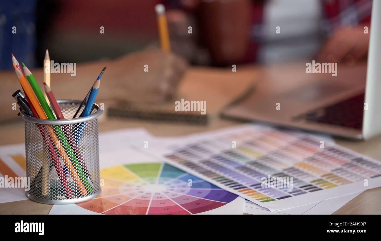 Female designers taking notes, colored pencils holder standing on color ...