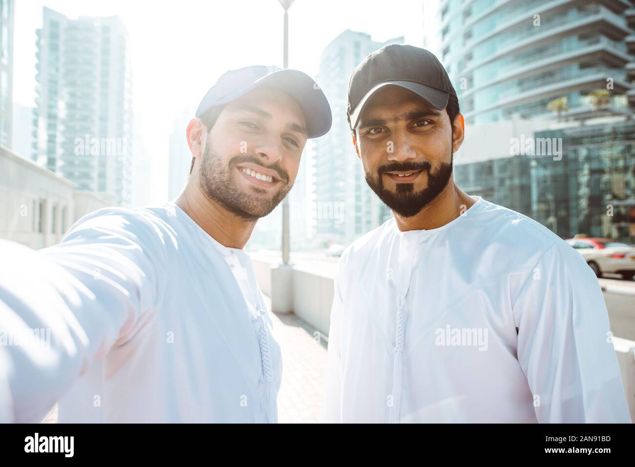 Two young men going out in Dubai. Friends wearing the kandura ...