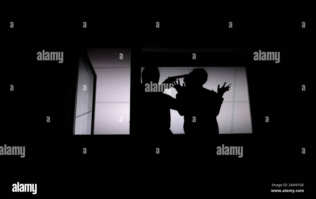 Silhouette Of Robber Putting Gun To Female Victim Temple Penetration