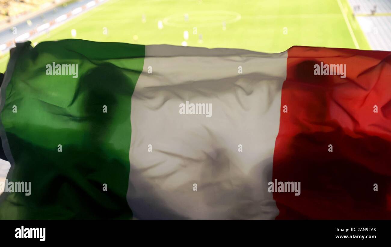 Italian supporters waving national flag, cheering for football team ...