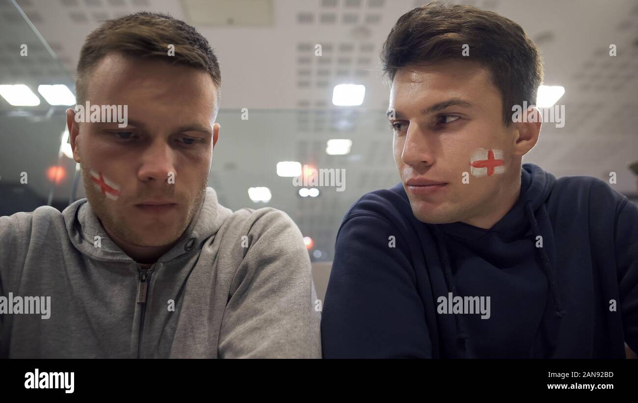 Upset football fans discussing losing match, showing desperate emotions ...