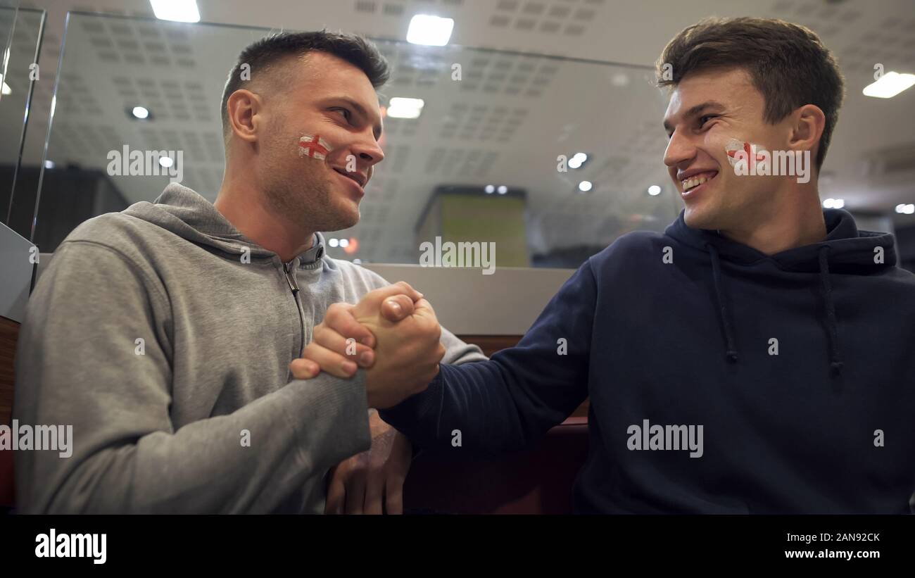 Two friendly football fans unexpectedly meet before match, male leisure ...