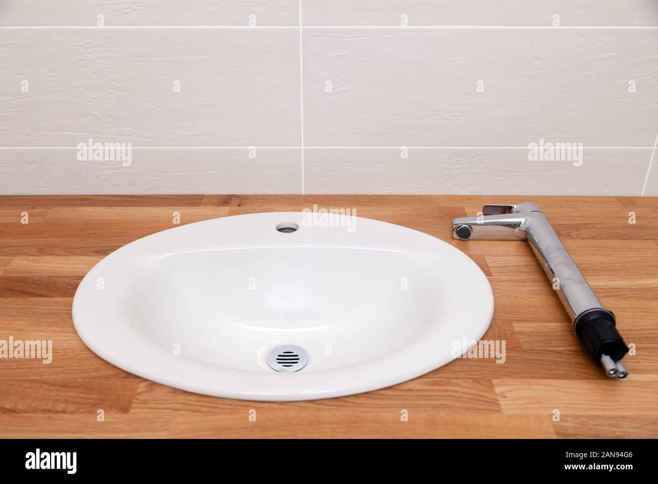 Closeup brown teak wooden empty tabletop with white round ceramic sink ...