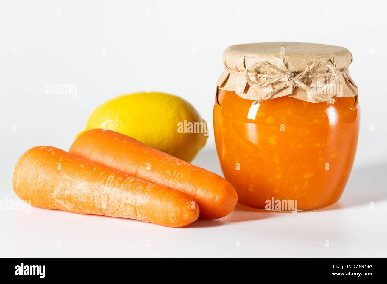 Juicy homemade carrot jam in glass jars on a white background. Side ...
