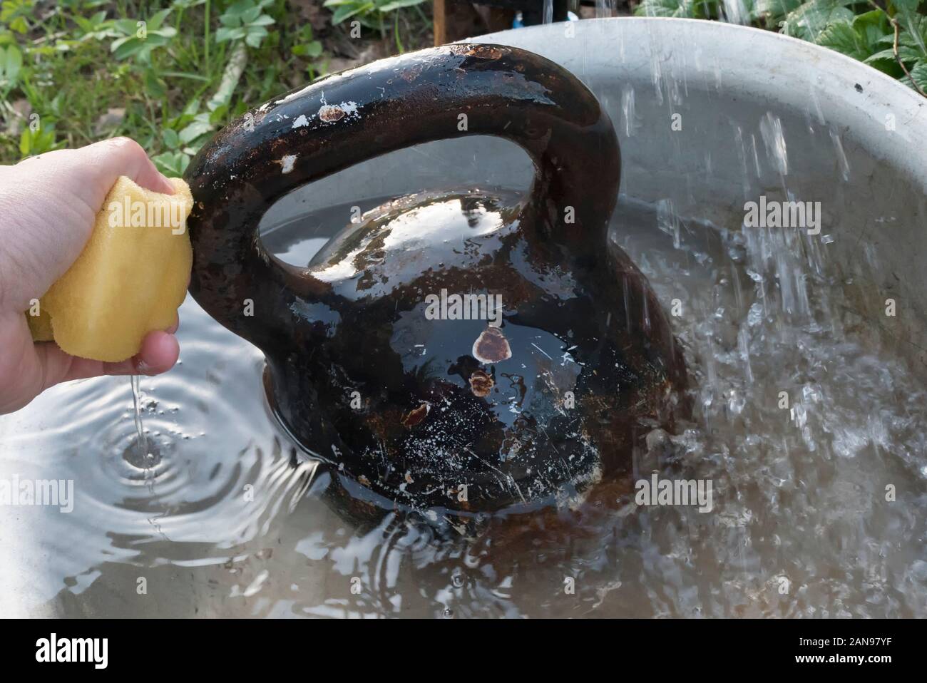Hand with sponge cleaning a dumbbell in basin Stock Photo - Alamy