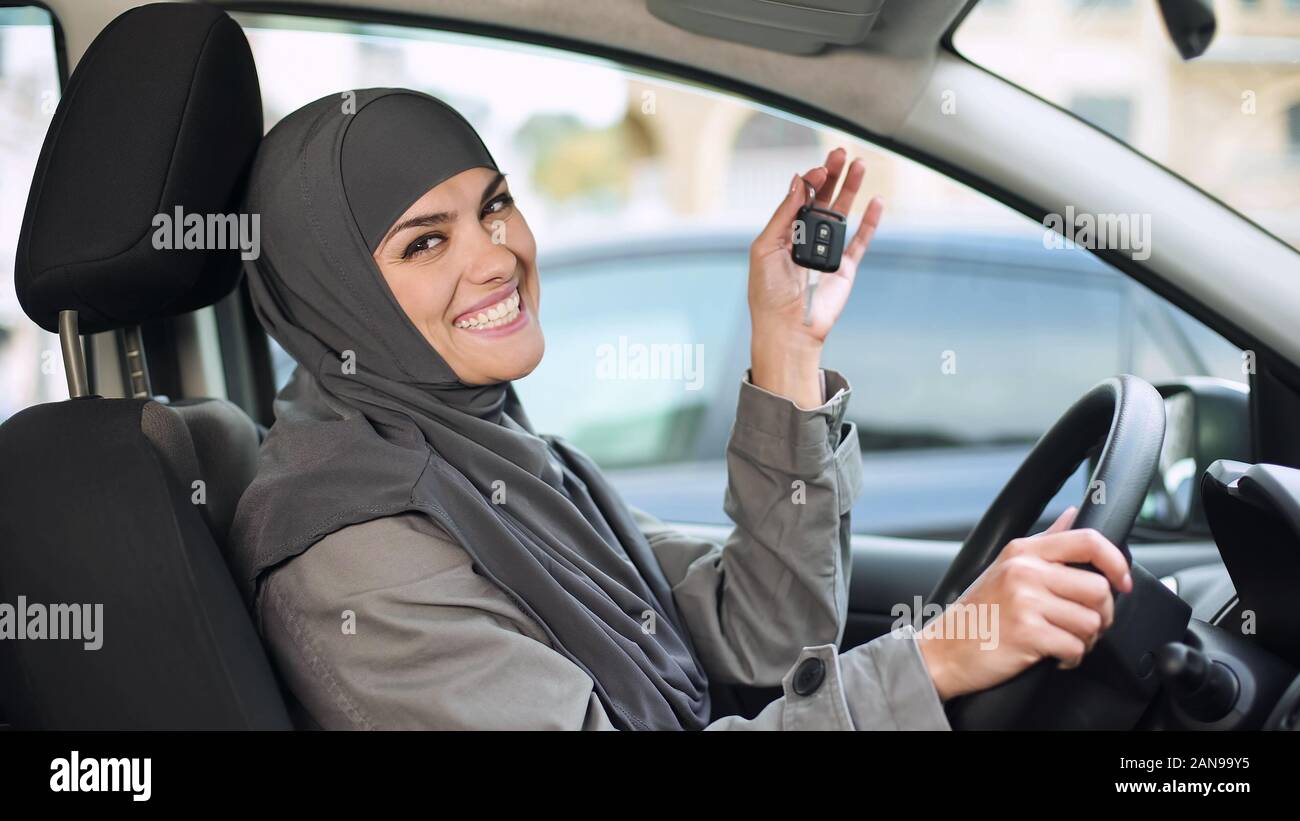 Smiling lady in hijab showing car key in camera, buying new auto ...