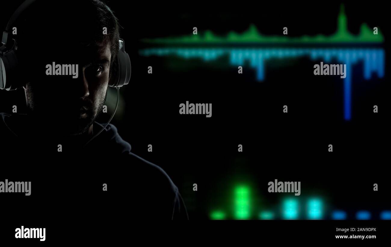Male in headphones listening sound, looking into future innovation ...
