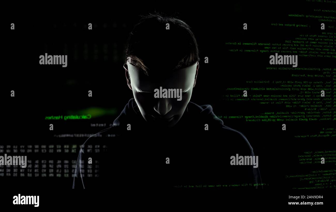Scary hacker in white mask attacking personal data, codes and numbers ...