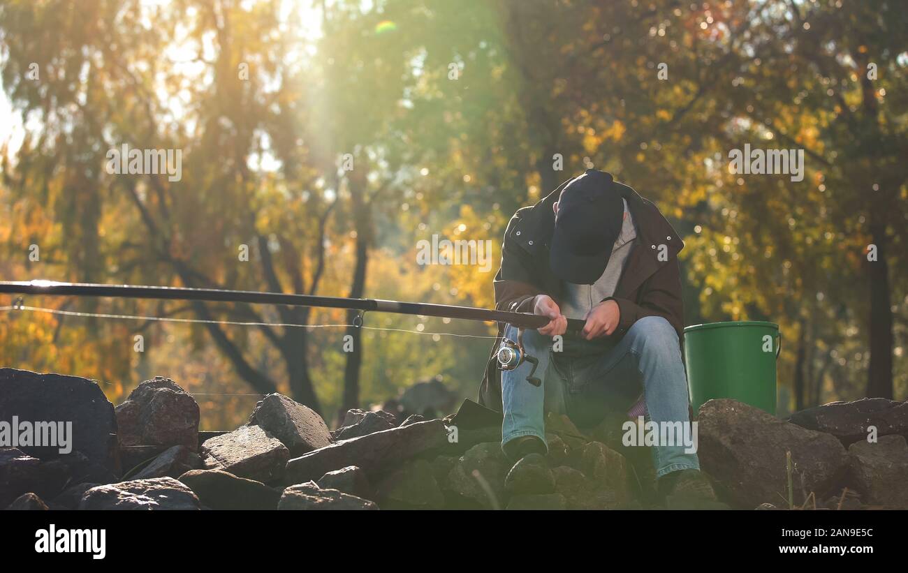 Tired fisherman falling asleep while fishing, long day outdoors ...