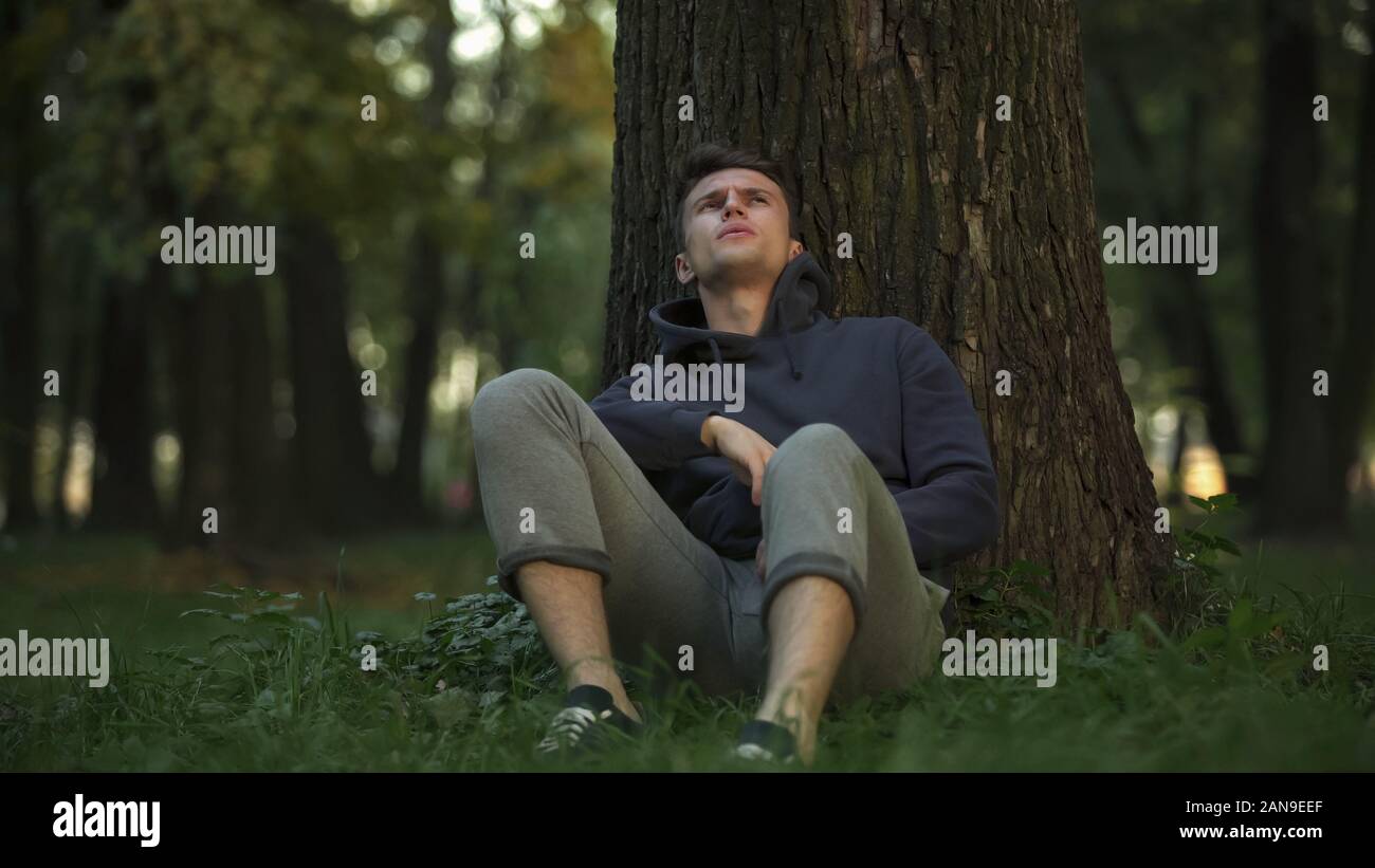 Sad stressed man under tree hi-res stock photography and images - Alamy