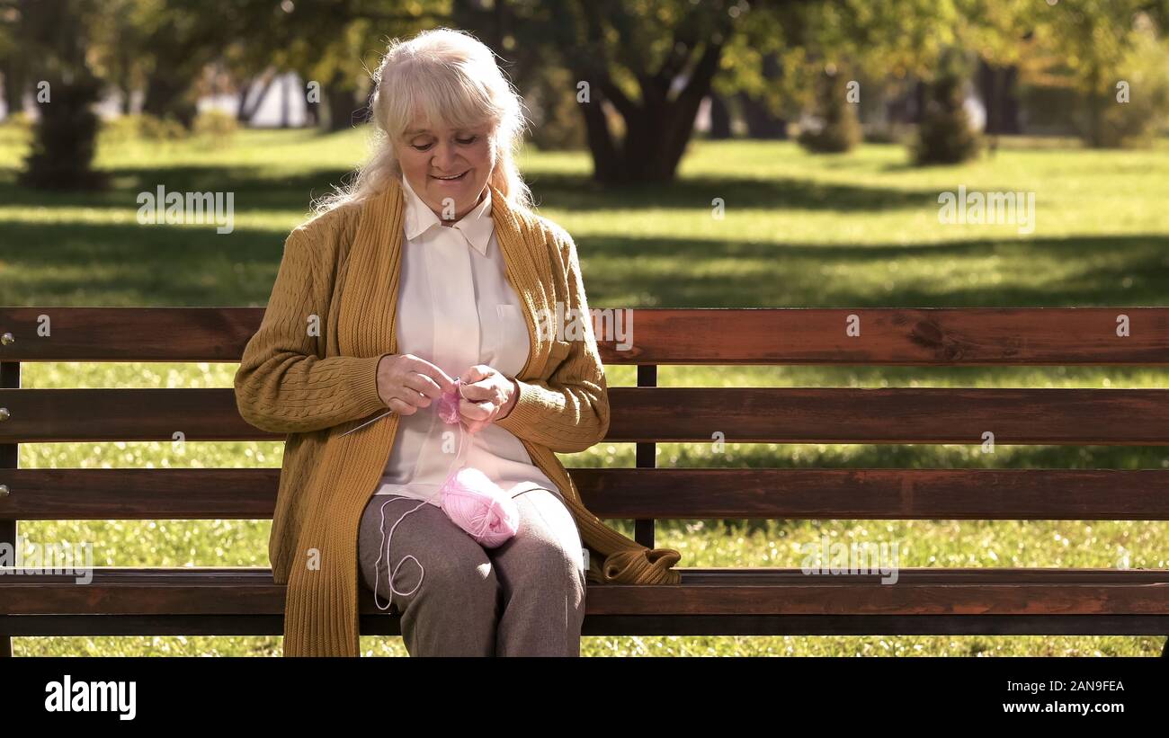 Dreamy old woman knitting little socks for her granddaughter, family ...