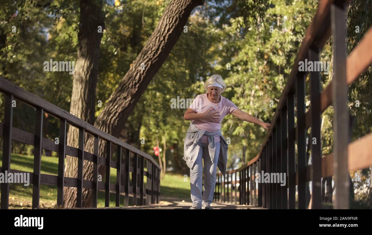 Senior woman running in park, suffering heartache, health problem in ...