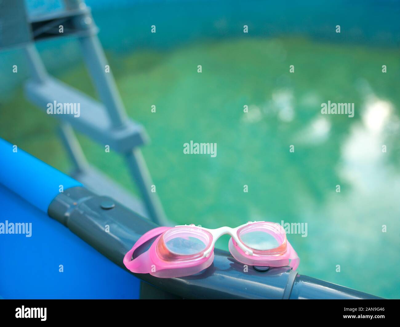 Glasses for swimming placed on the edge of outdoor swimming pool Stock ...