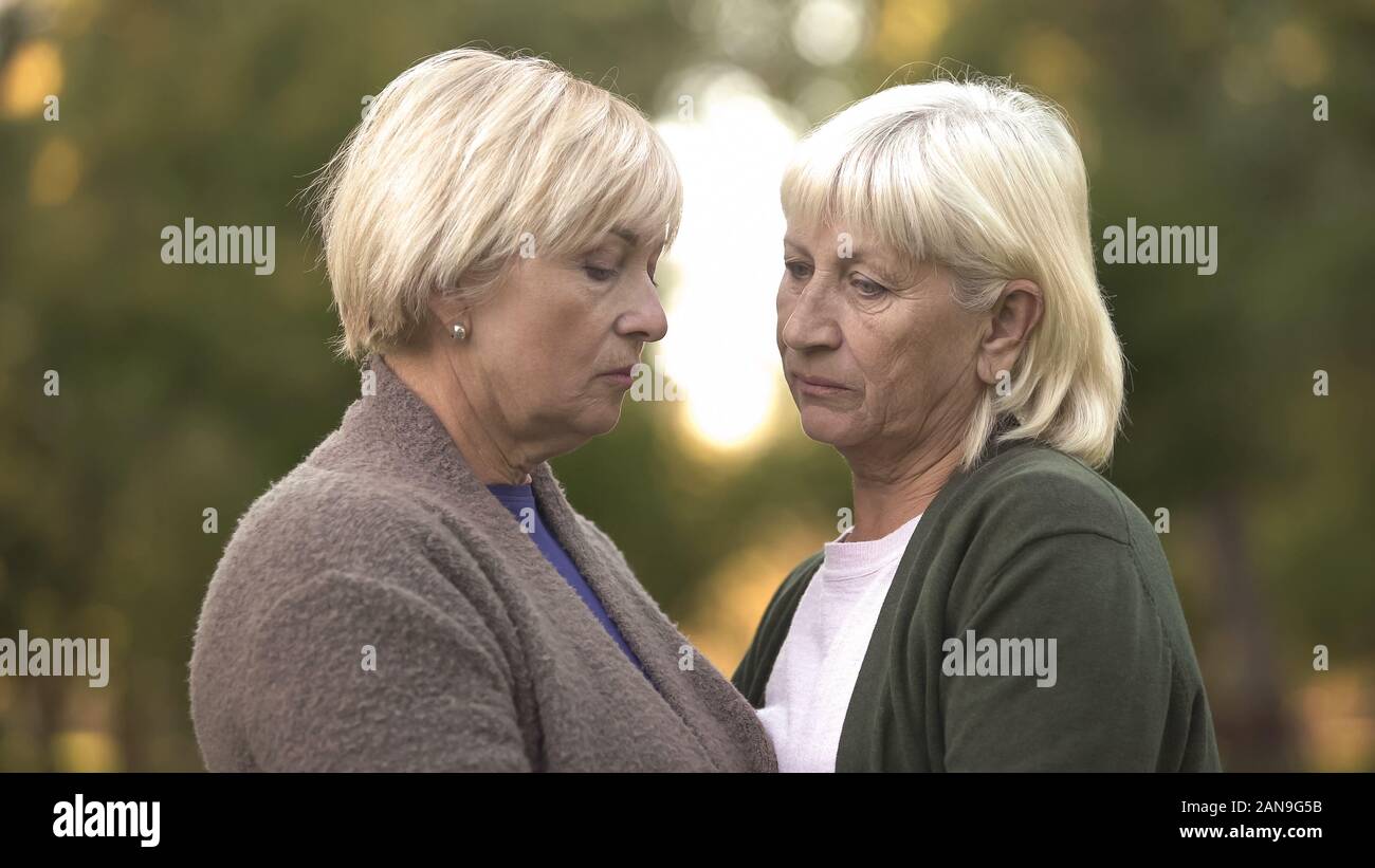 Two sad women with sorrowful eyes supporting each other, family loss ...