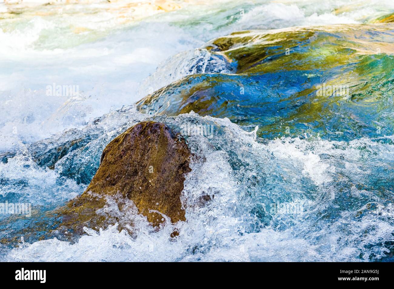Clear mountain river water tumbling over boulders in the Nepal ...