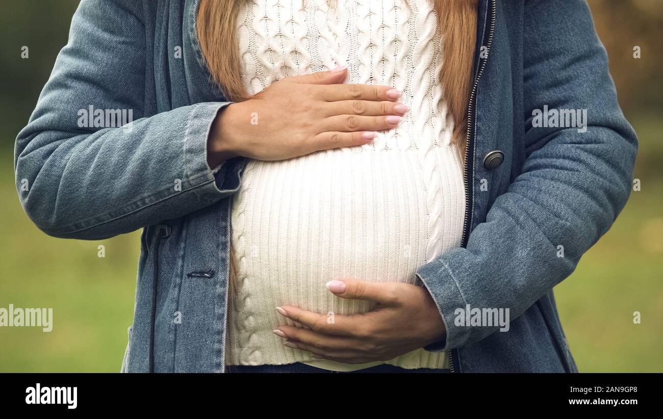 Woman touching pregnant belly close up, expecting newborn, maternity ...