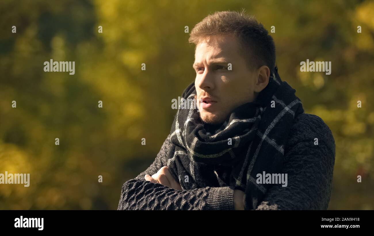 Frozen man in autumn park feeling cold, bronchitis risk, warm clothes ...