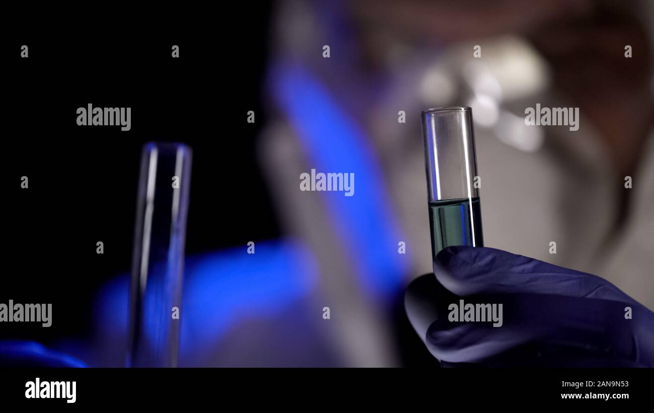 Test tubes in hands of scientist closeup, mixing chemical substances ...