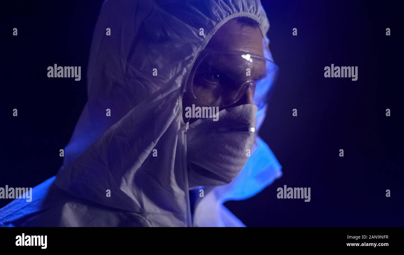 Chemist in lab costume wearing mask, secret manufacture of biological ...
