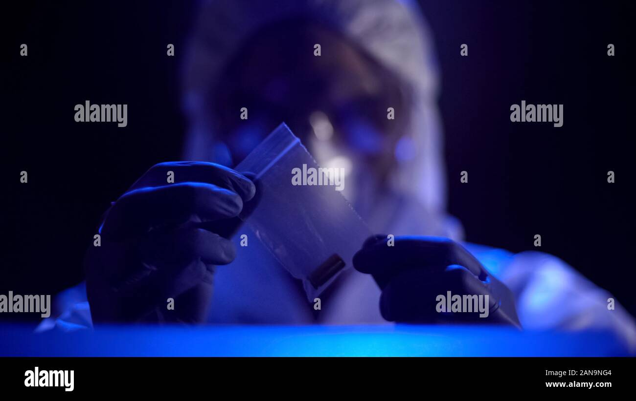 Criminal specialist inspecting crime scene, examining bullet evidence ...