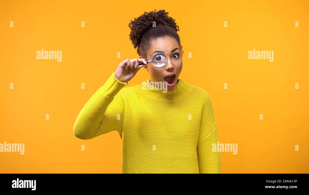 Curious afro-american woman looking magnifying glass, having fun ...
