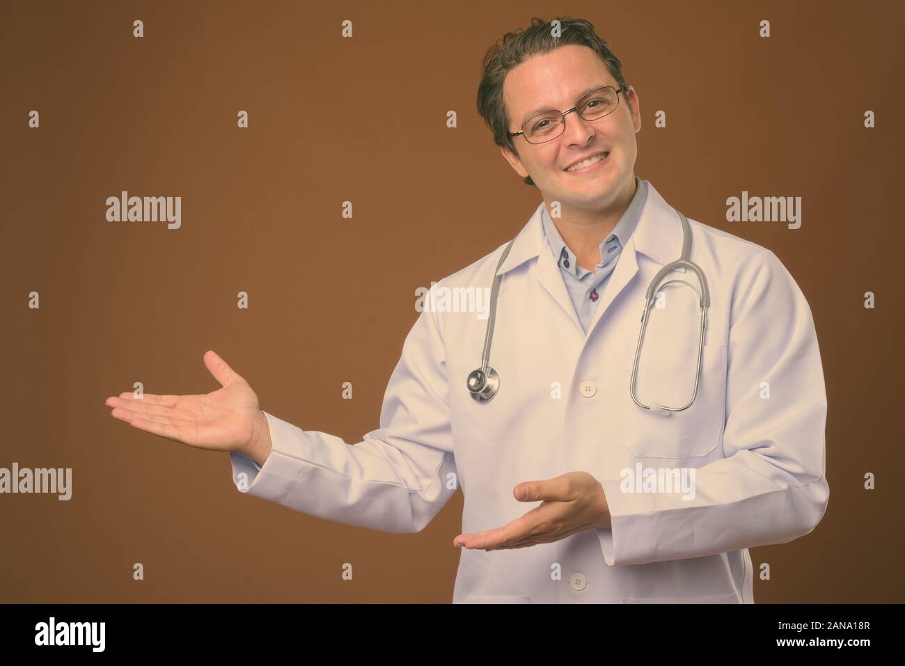 Studio shot of Italian man doctor against brown background Stock Photo ...