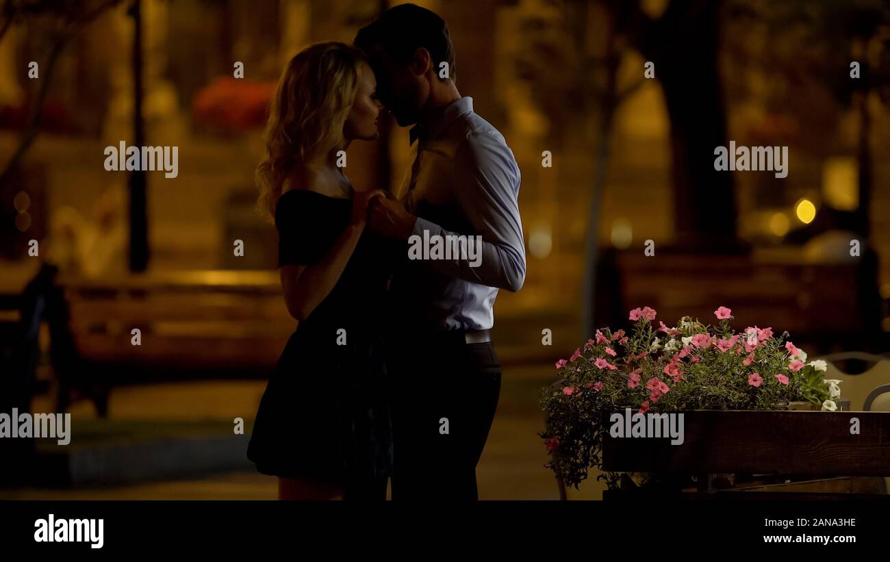 Boyfriend and girlfriend dancing in dark, romantic date in central park ...