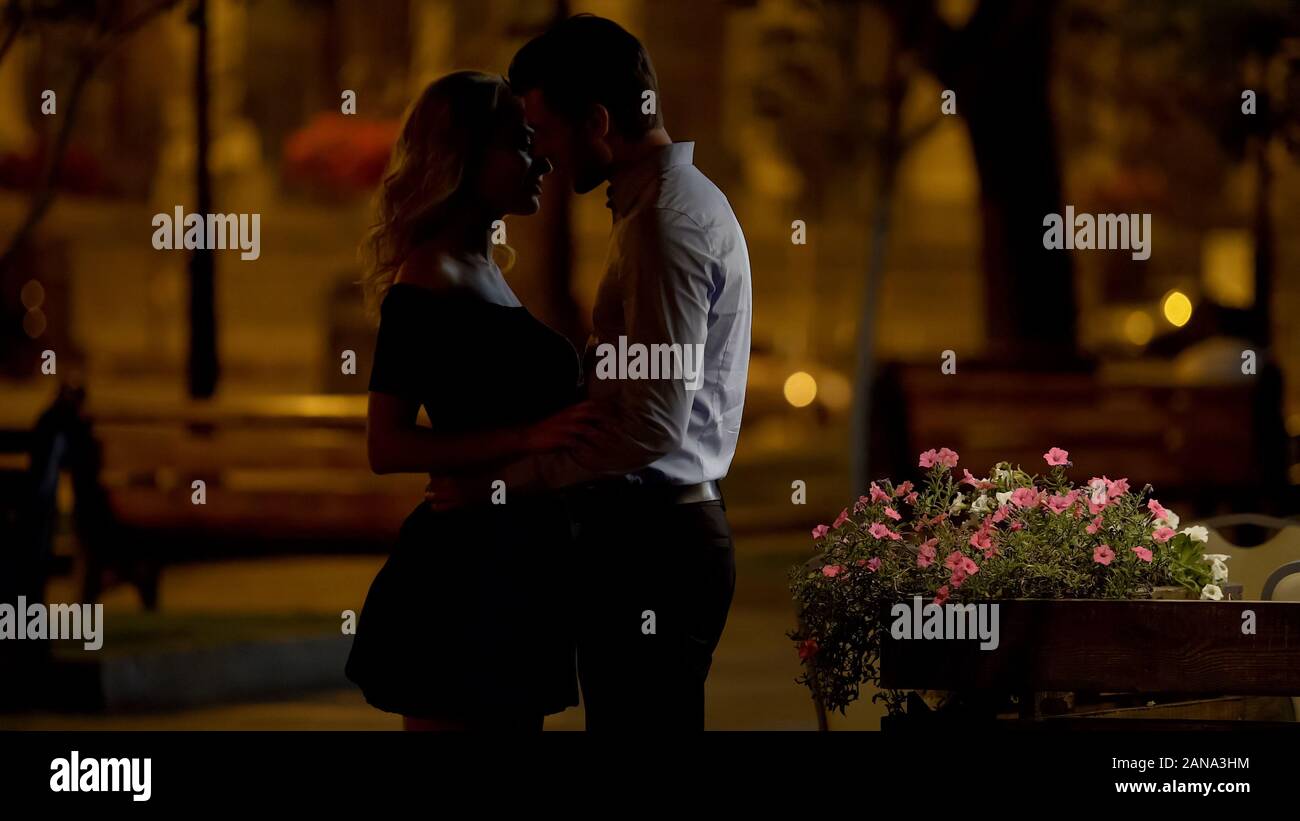 Couple of beloved going to kiss, romantic date in park, evening time ...