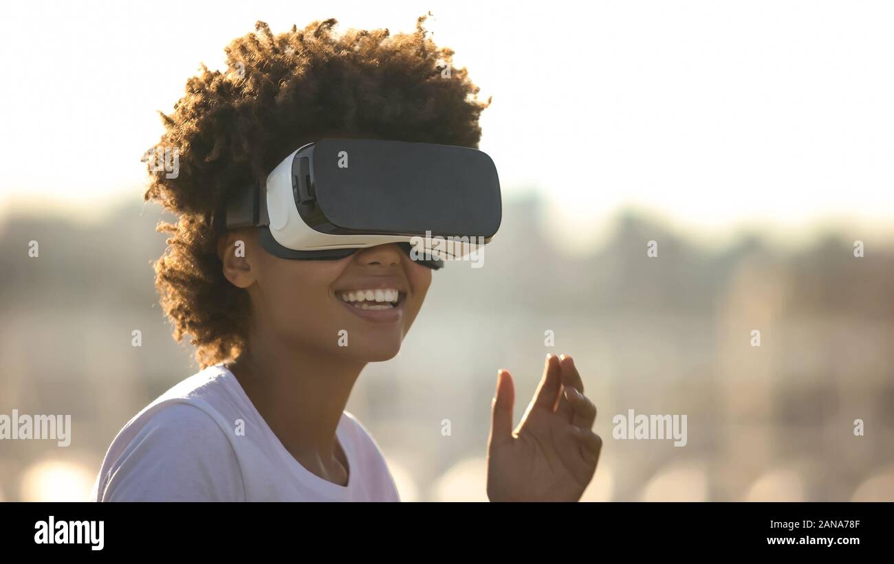 Cheerful afro-american woman in virtual reality goggles smiling ...