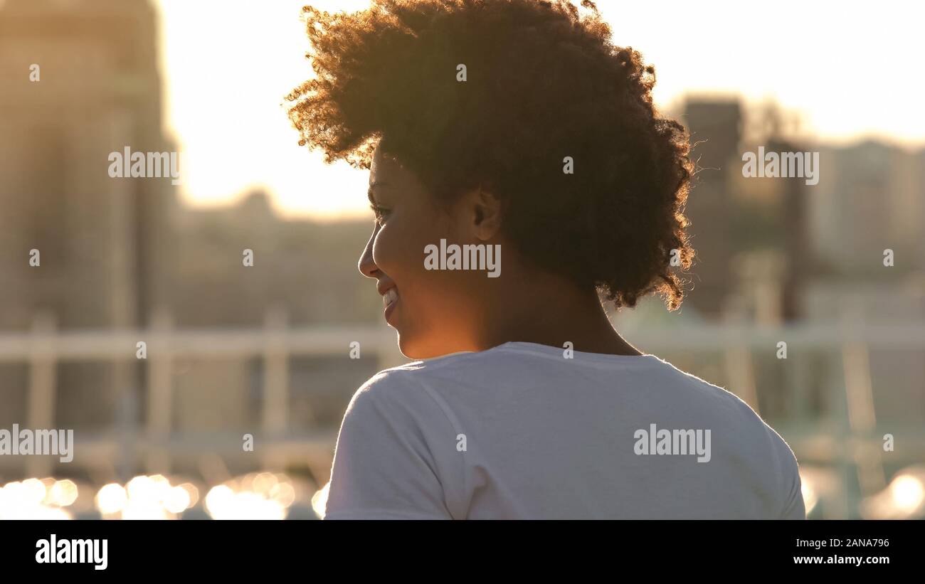 Excited african american woman enjoying morning sun outdoors, joy, back ...