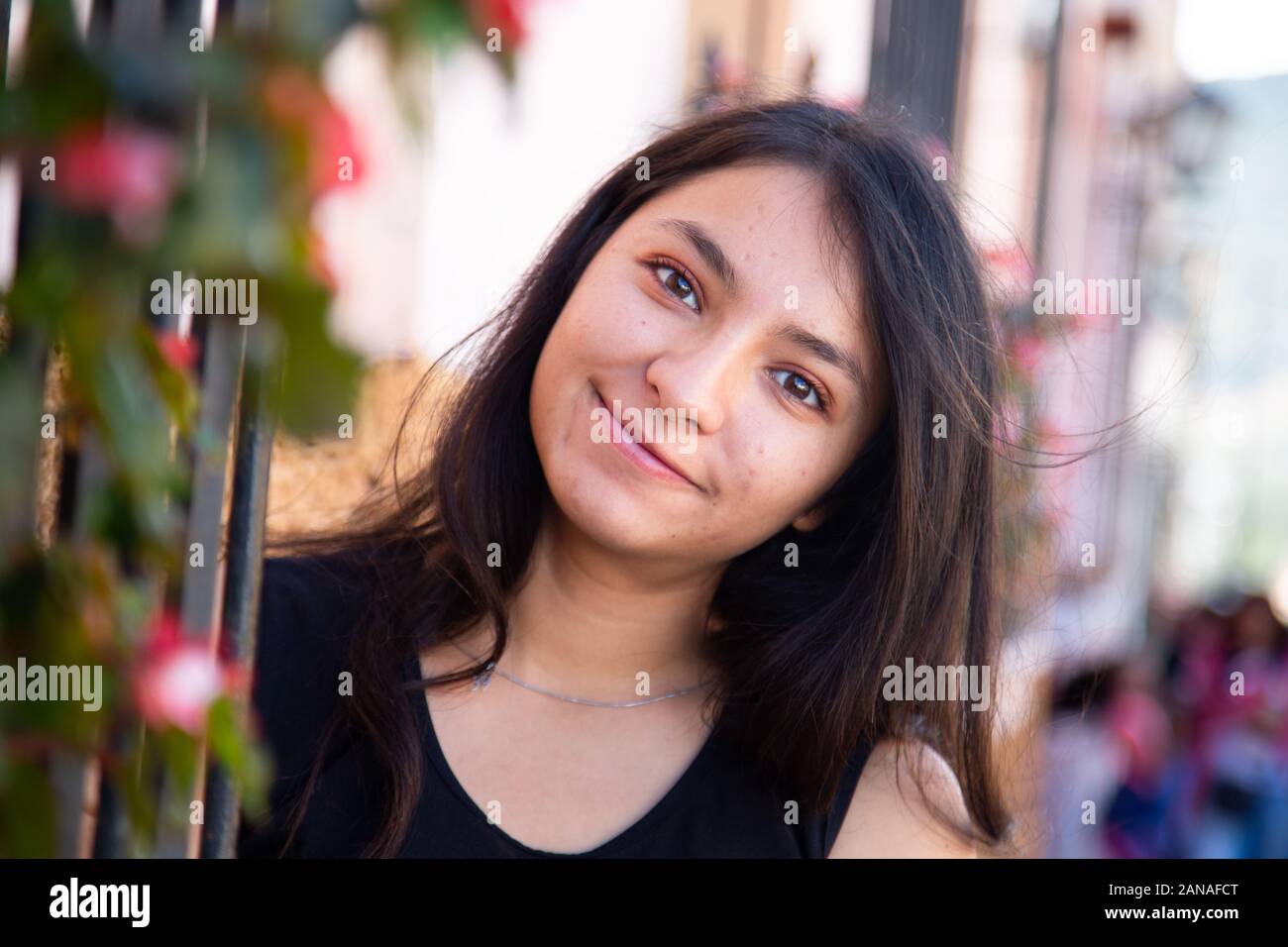 Hispanic tourist posing on the balcony full of flowers in Guatemala ...