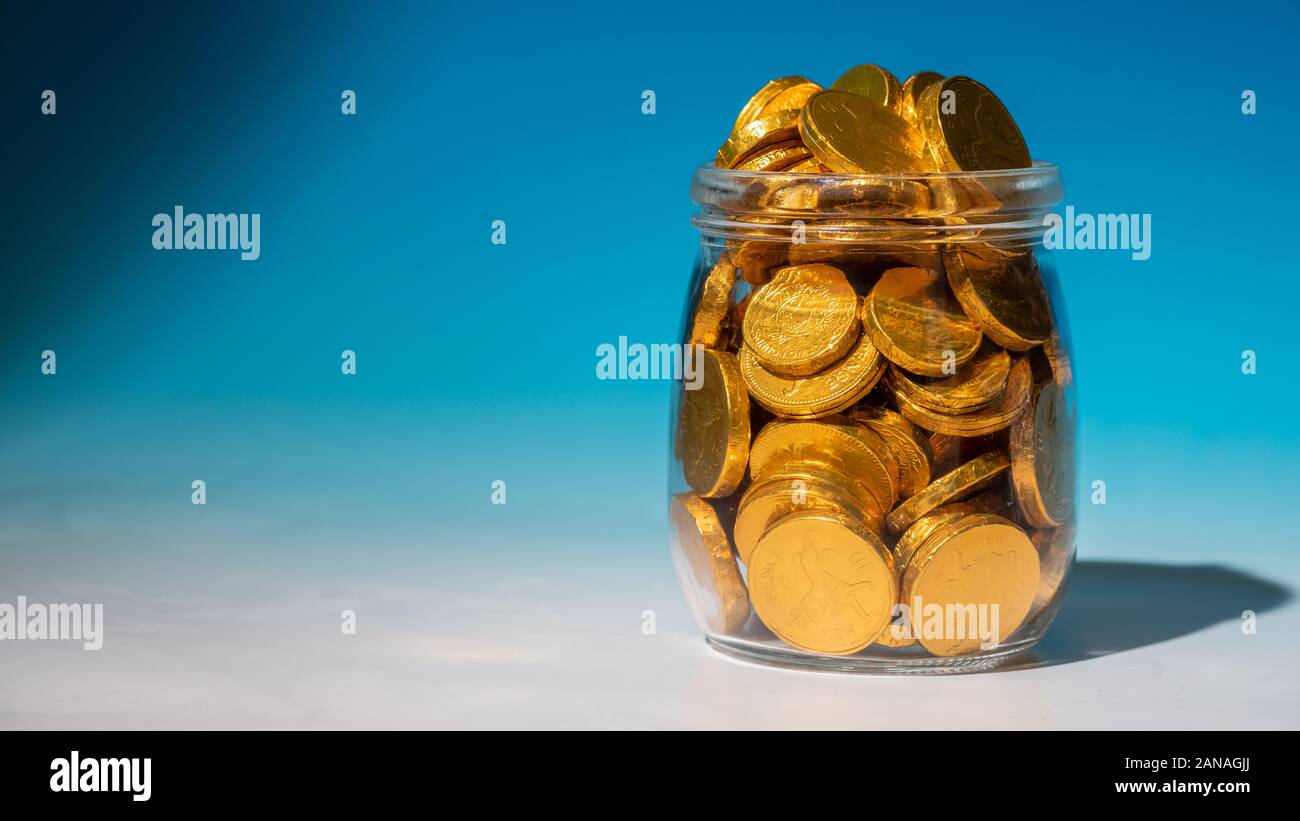 Glass jar full of gold coins Stock Photo - Alamy