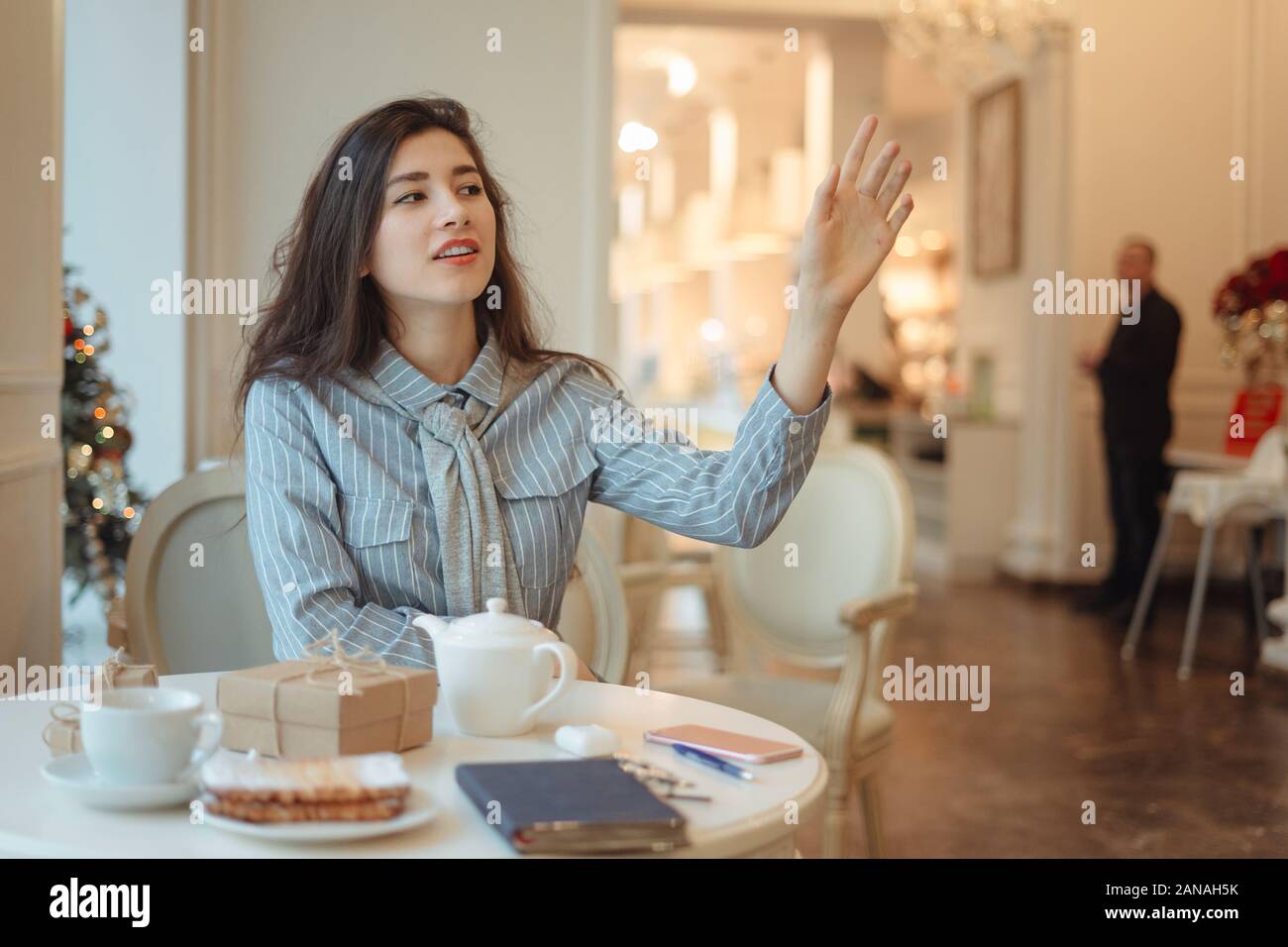 Young women calling the waitress Stock Photo - Alamy