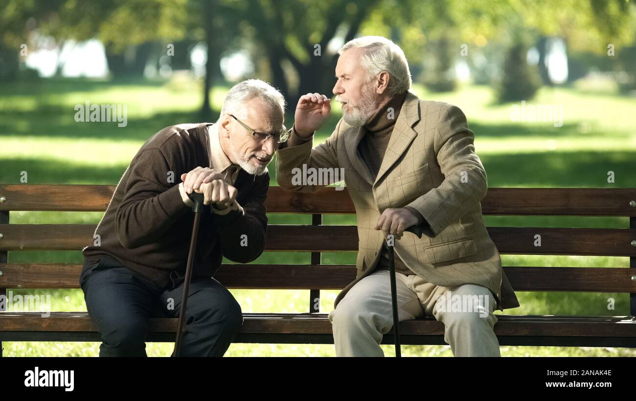 Senior gentlemen talking to his hearing impairment old friend, health ...