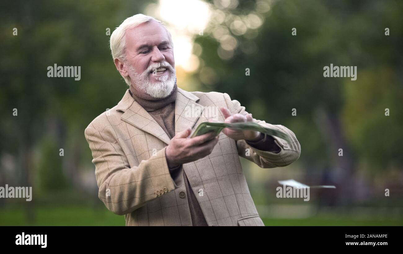 Handsome man throwing dollar hi-res stock photography and images - Alamy