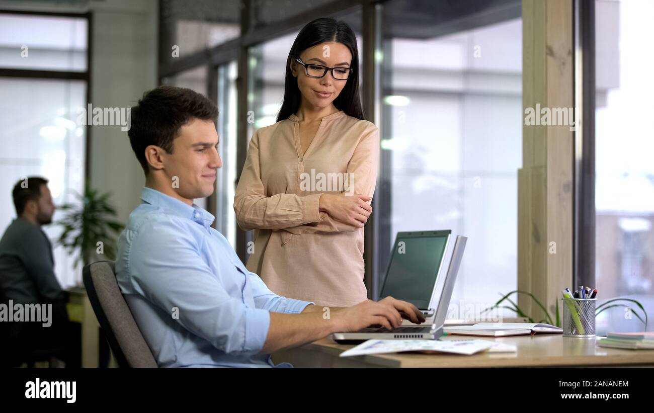 Female boss and male employee looking laptop, working on business ...