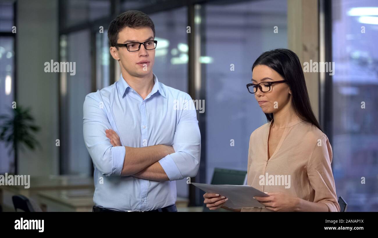 Nervous secretary holding documents feeling scared of male boss, office ...