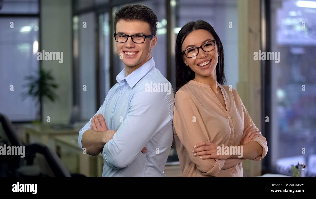 Cheerful employees posing for camera, work for young and energetic ...