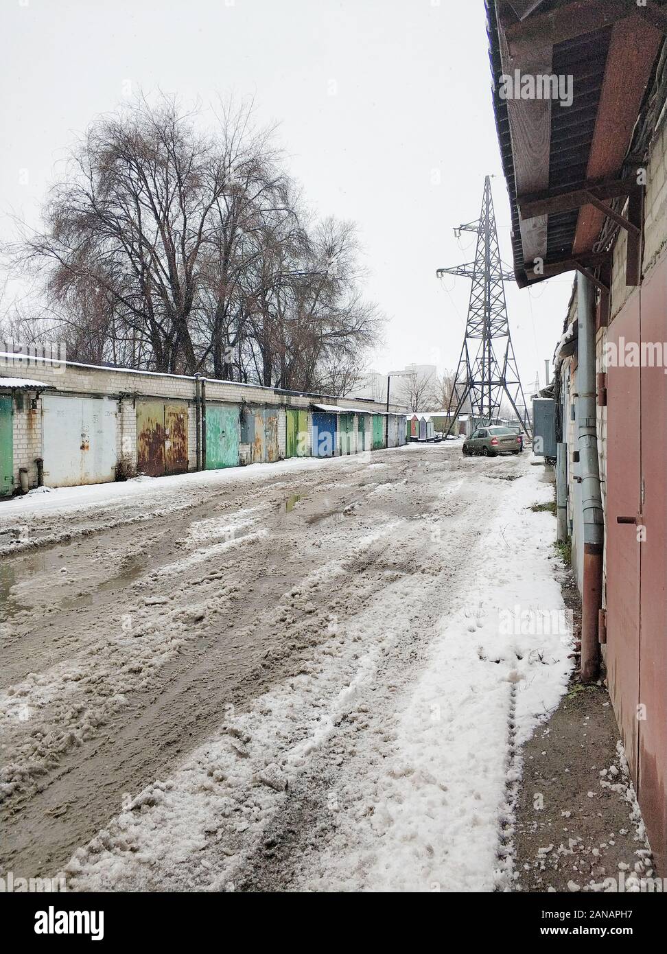 Winter dirty broken road in a garage cooperative. Gray depressing moody ...